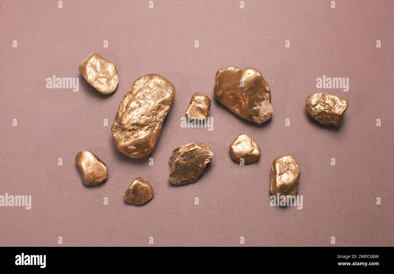 many golden nuggets on brown surface Stock Photo - Alamy