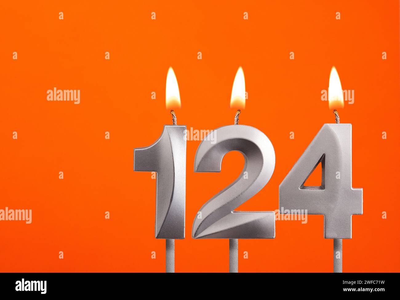 Candle number 124 - Birthday in orange background Stock Photo - Alamy