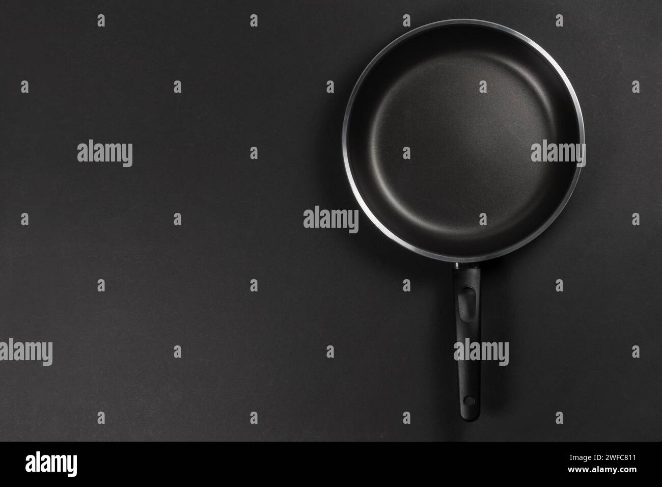Black fry pan on dark background. top view Stock Photo - Alamy
