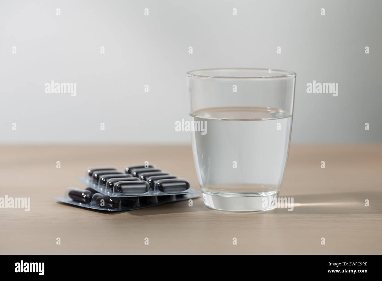 Drinking water and medicine for treating illnesses on the wooden table ...