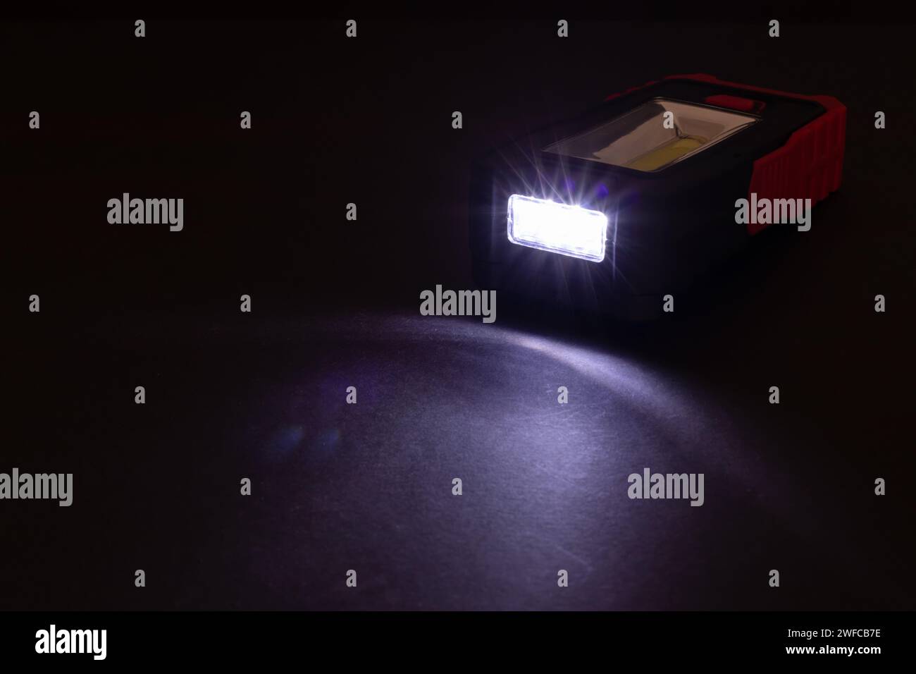 Flashlight and a beam of light in darkness. A modern led lamp with ...