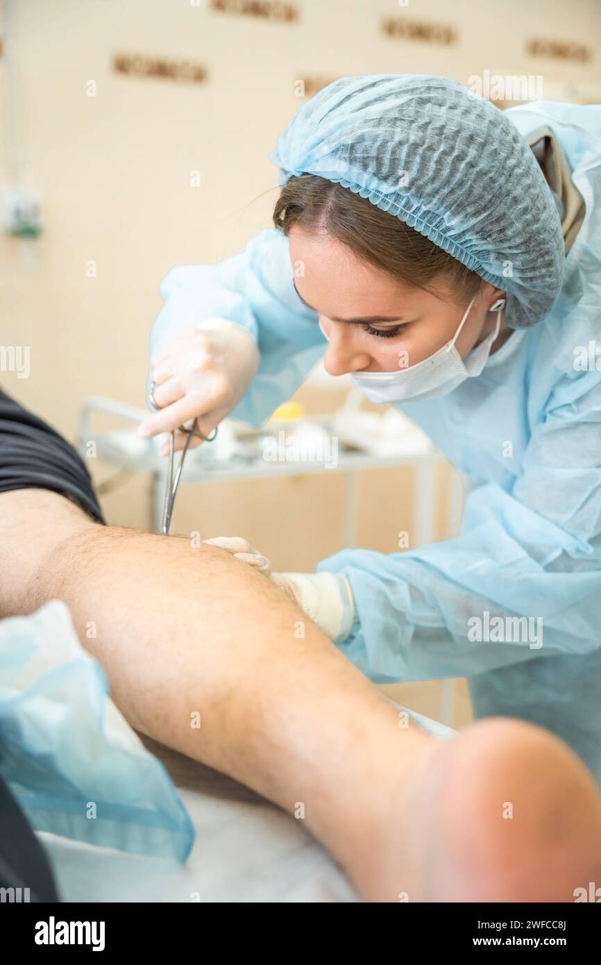 Dermatologist surgeon stitching up a wound after skin surgery ...