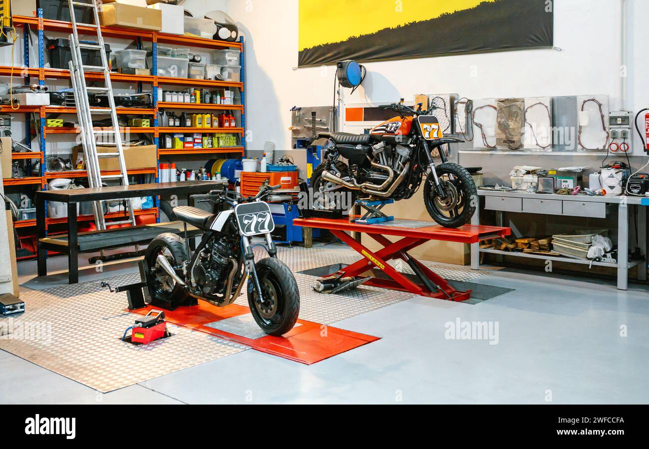 Empty motorcycle workshop with custom motorbikes over platforms ready ...