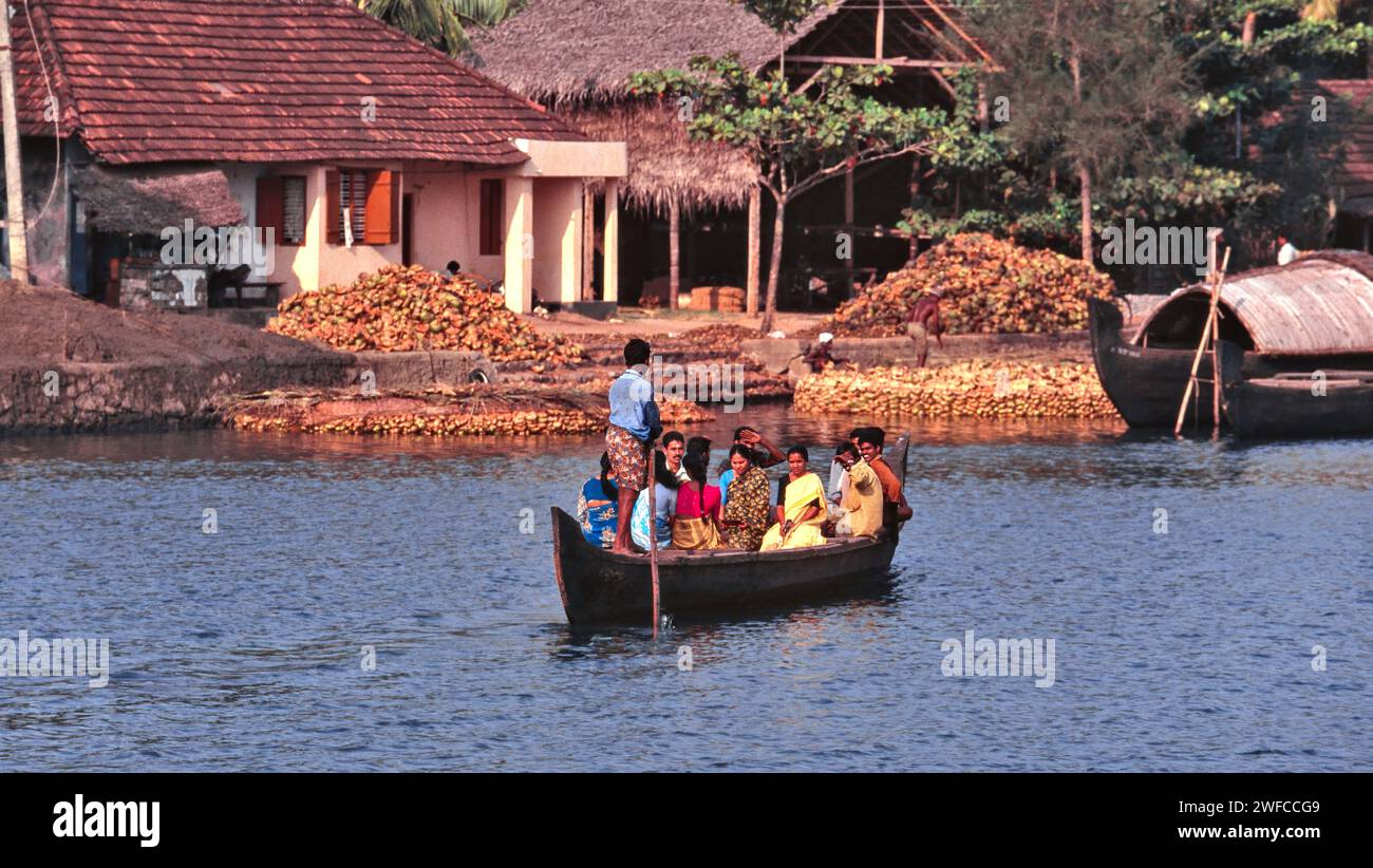 Rural India people in a traditional boat and coconut husks of a coir ...