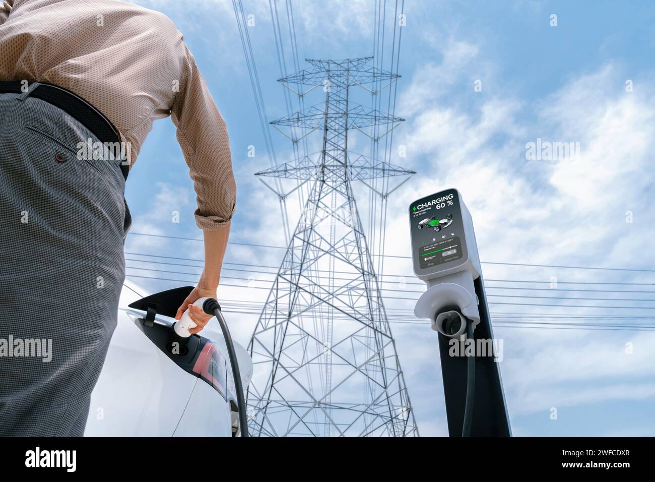 Man recharge EV electric car battery at charging station connected to ...