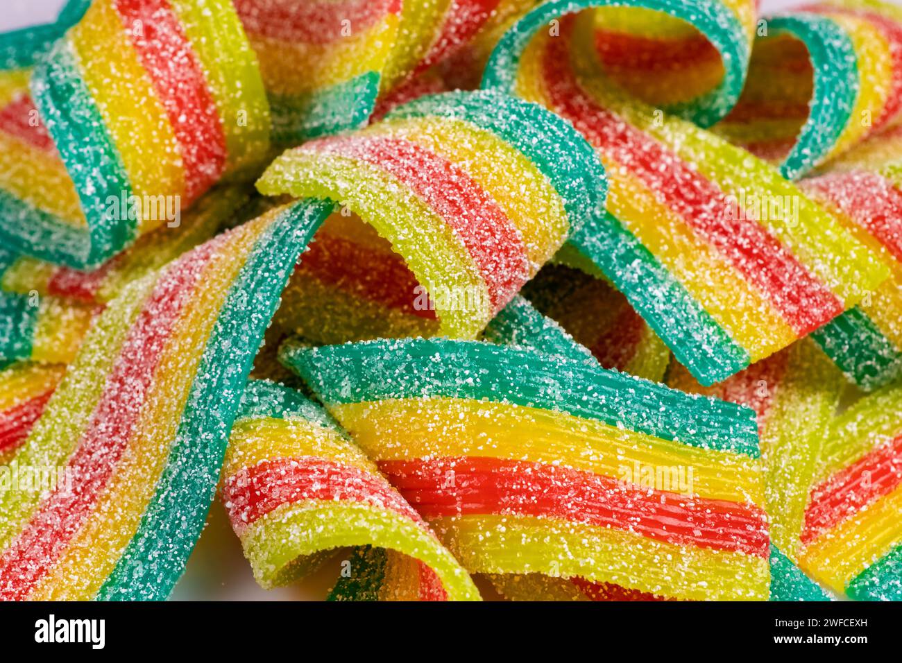 Colorful jelly candies strips in sugar sprinkles. Sour flavored rainbow ...