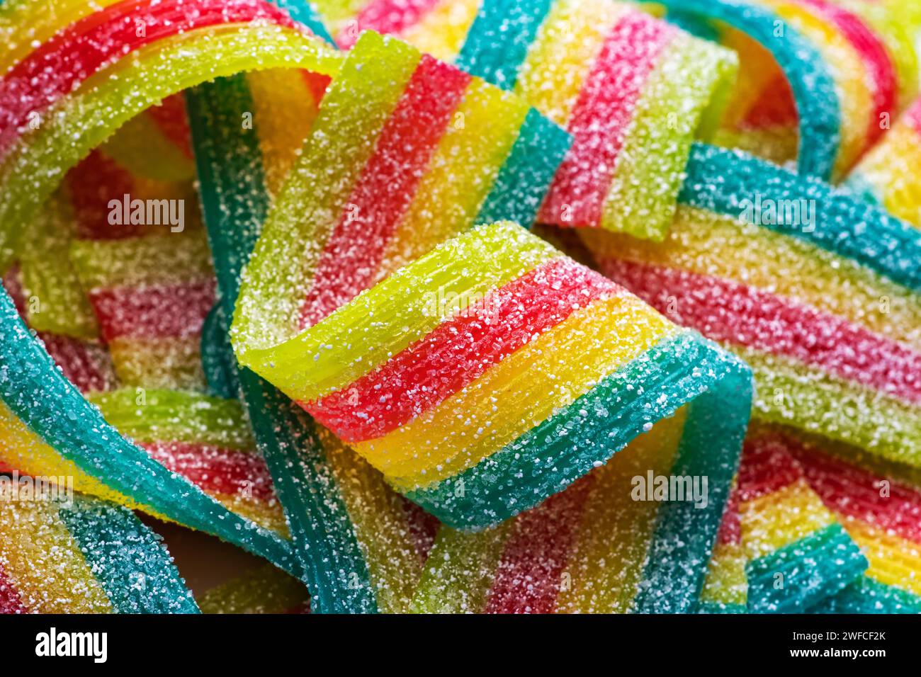 Colorful jelly candies strips in sugar sprinkles. Sour flavored rainbow ...