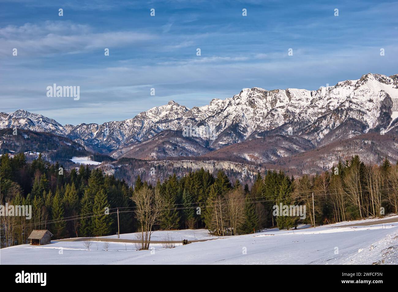 A snow-covered hill with towering mountains in the World Heritage ...