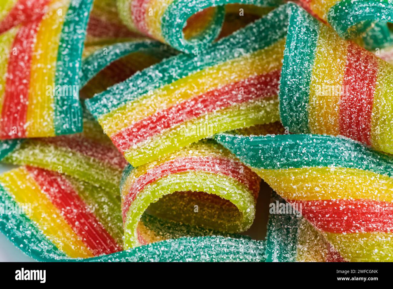 Colorful jelly candies strips in sugar sprinkles. Sour flavored rainbow ...
