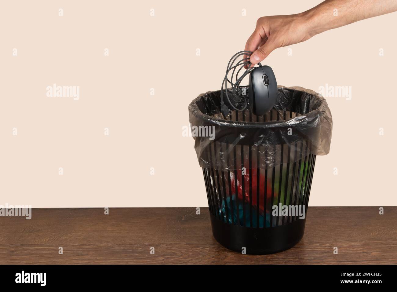 throwing a computer mouse in the trash bin, a computer mouse in hand in ...
