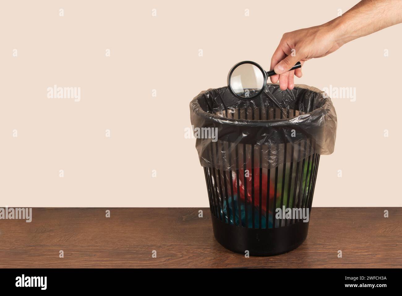 throw a magnifying glass in a trash can, magnifier in hand in front of ...