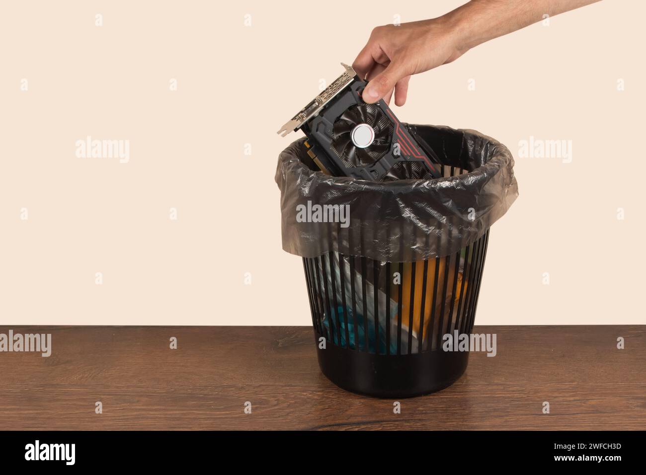 throwing a video card in the trash bin, a computer video card in hand ...