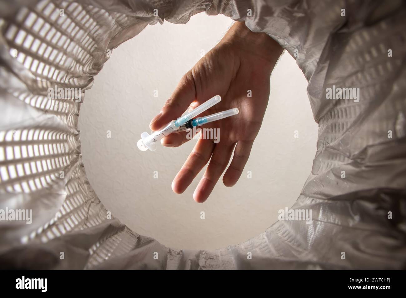 Hand throws syringe into trash bin with package. Inside view Stock ...