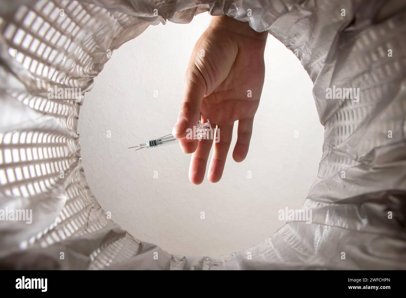 Hand throws syringe into trash bin with package. Inside view Stock ...