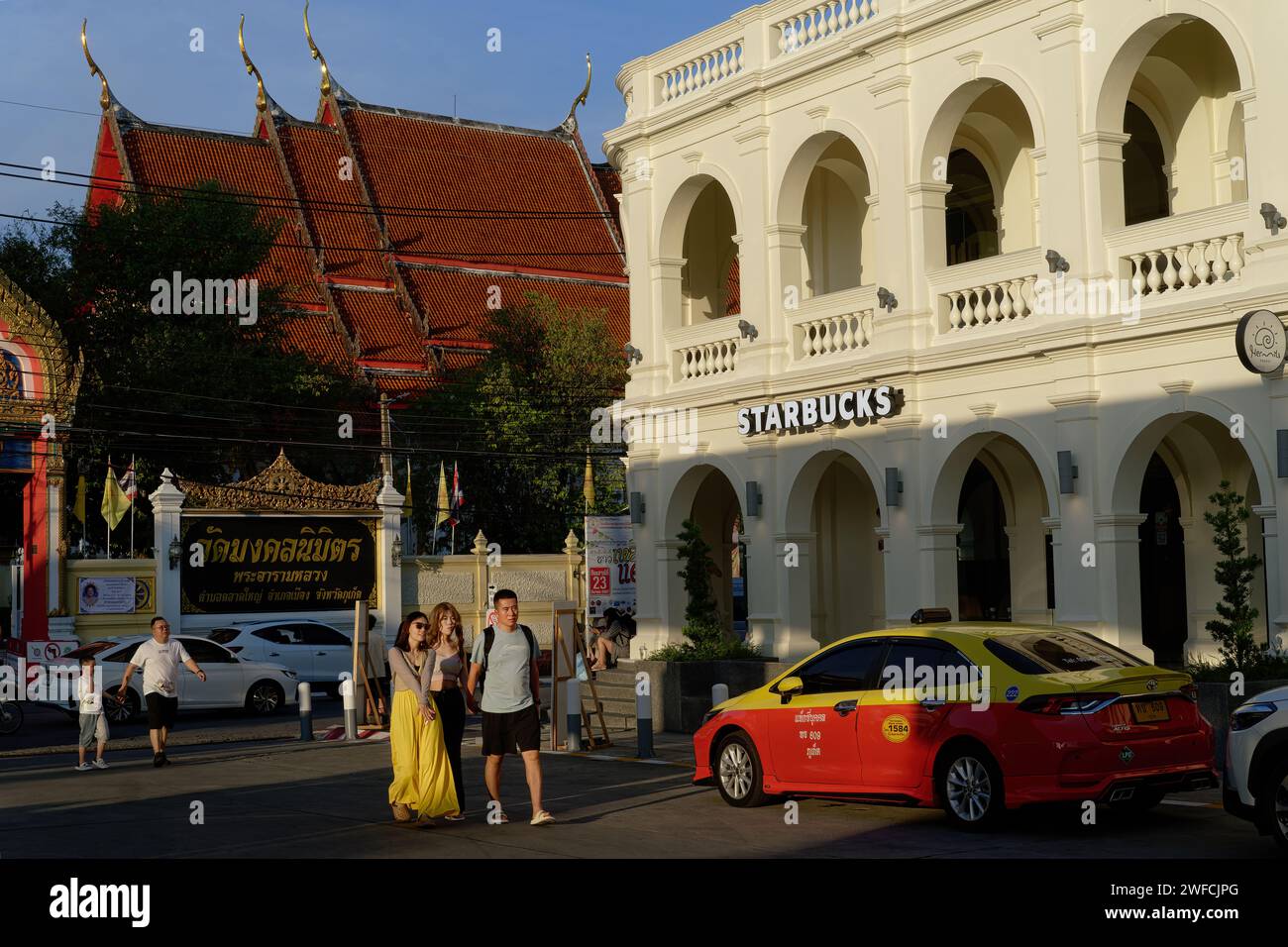 Chinese tourists pass a Starbucks outlet in the Old Town area of Phuket ...