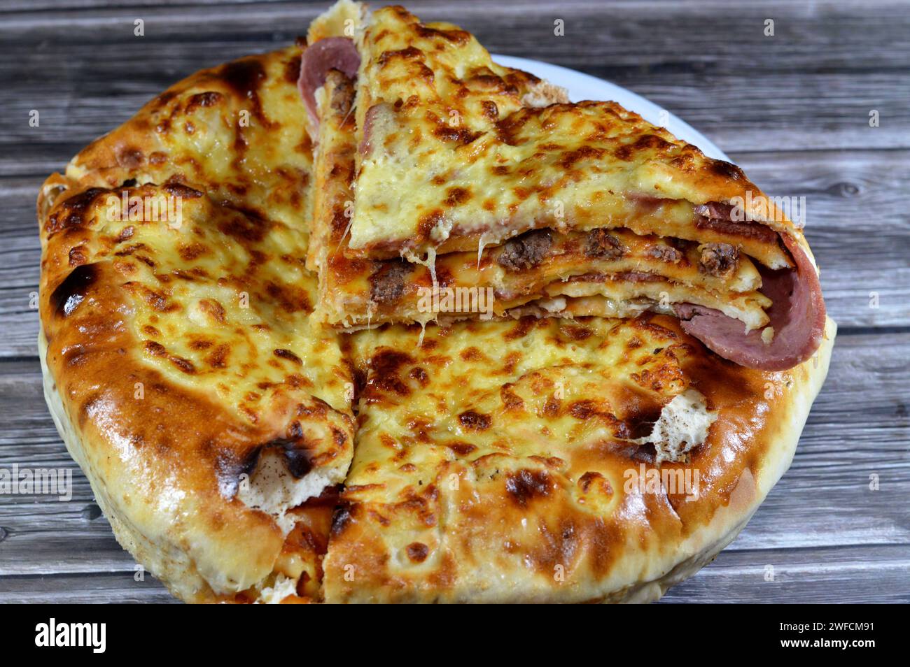 Multi-layers baked pizza cake, consists of layers of salami, barbeque ...