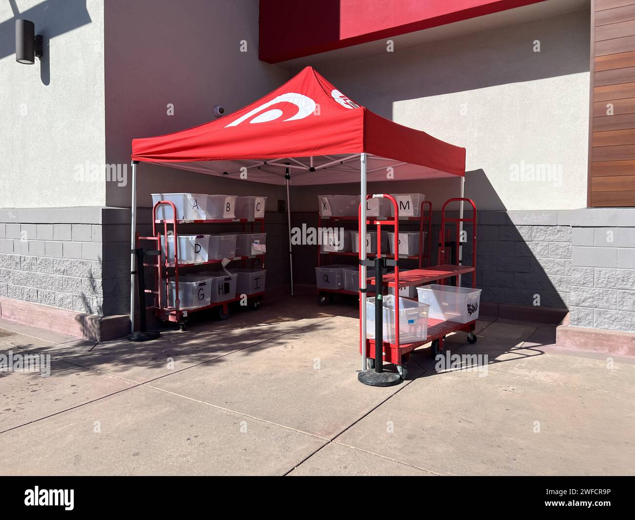 Drive-up pick-up station with red canopy and organized labeled bins ...