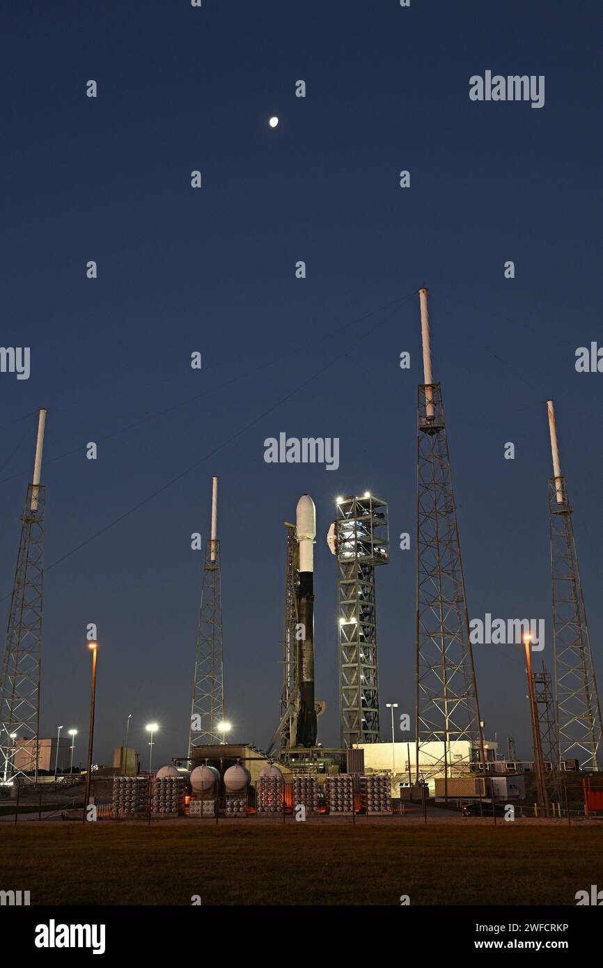 The moon hangs above a SpaceX Falcon 9 rocket as it is prepared to ...