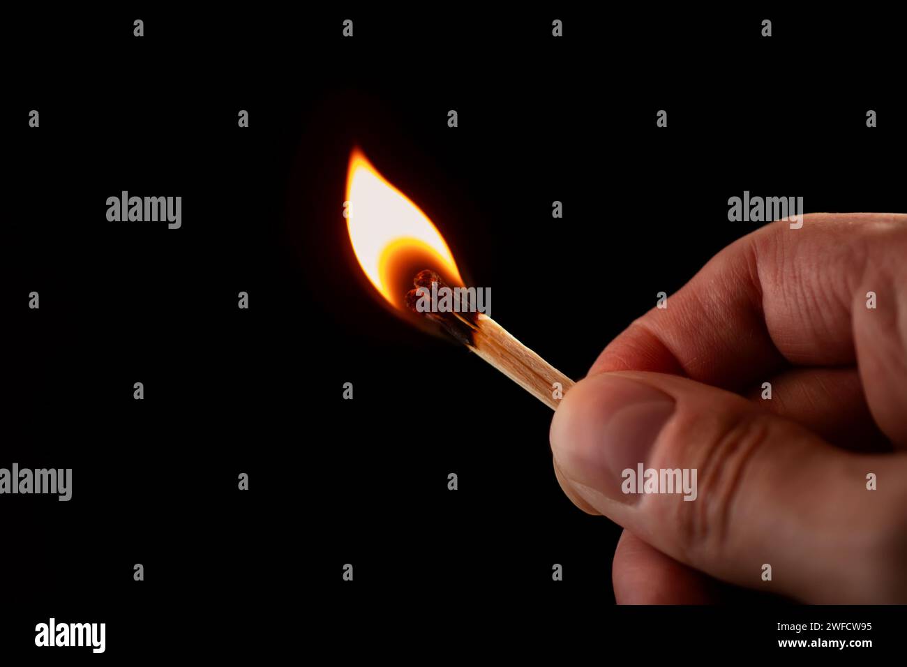 Hand holding burning match stick. Photo on a black background Stock ...