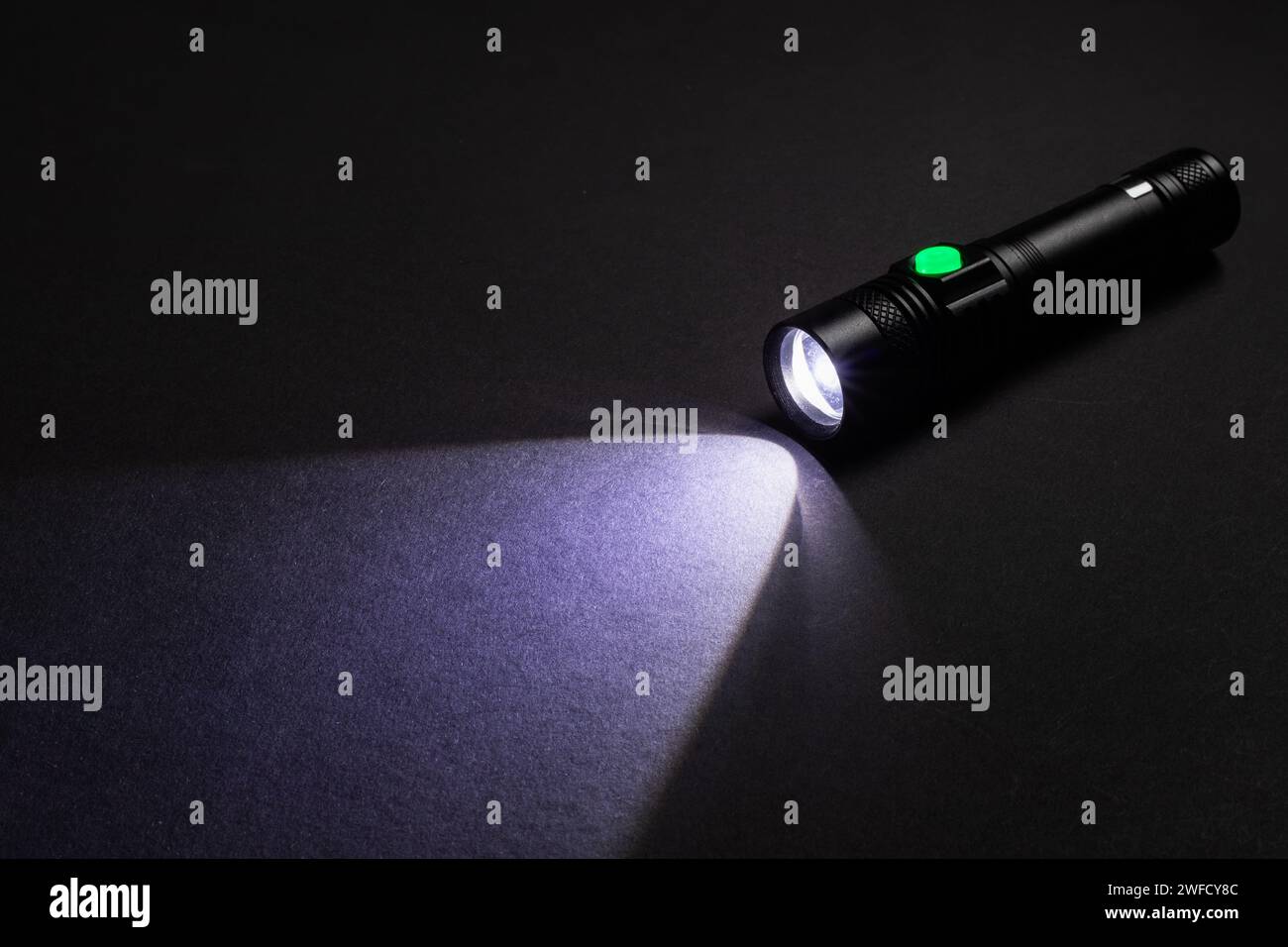 Flashlight and a beam of light in darkness. A modern led lamp with ...