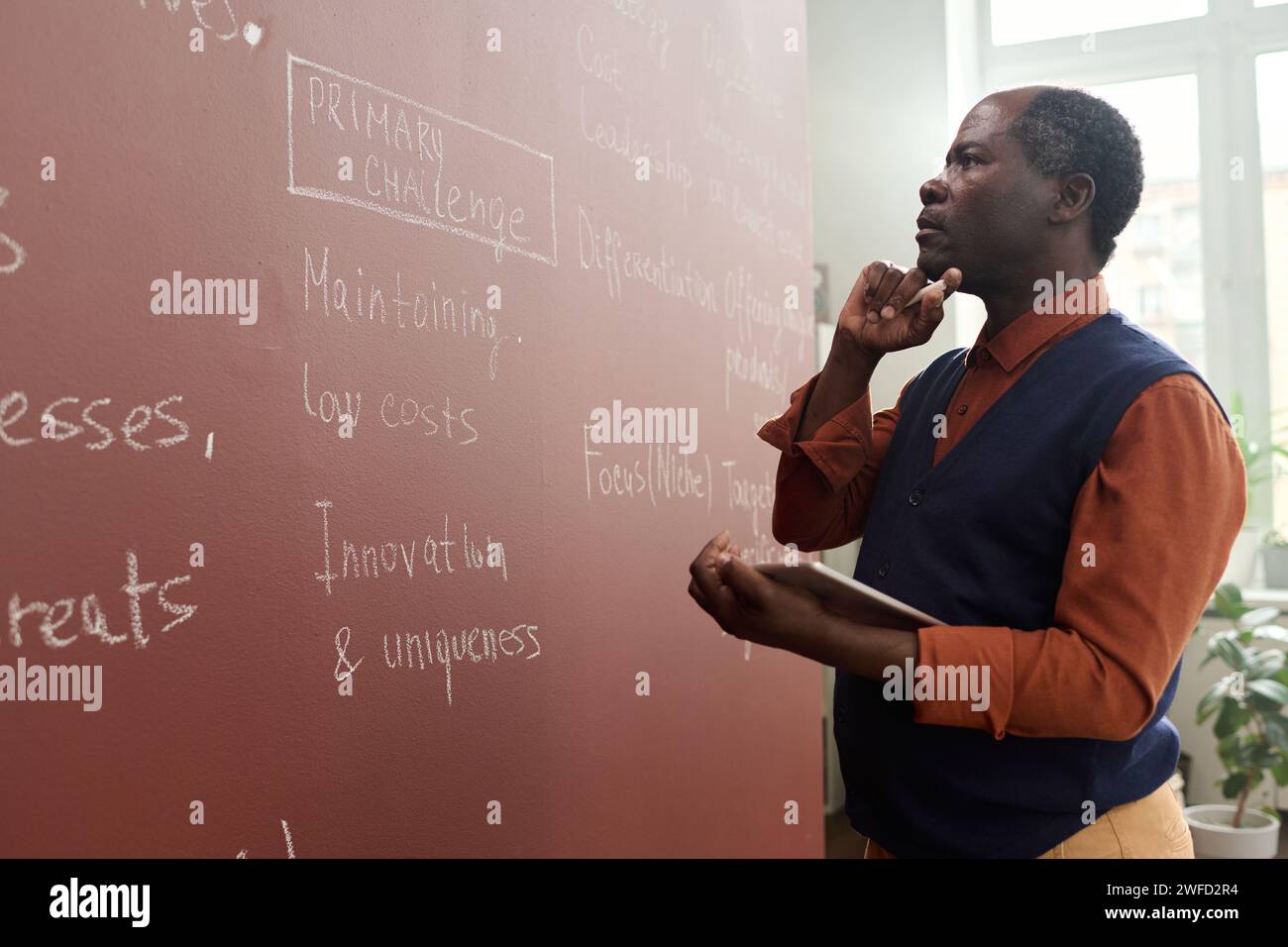 Side view portrait of senior Black college professor thinking by ...