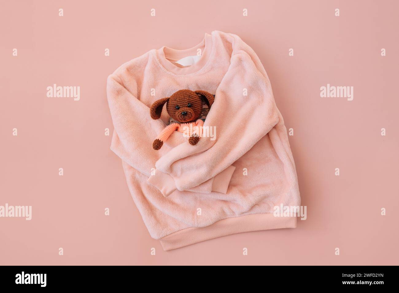 Soft pink jacket hugging a stuffed toy on a pink background Stock Photo ...