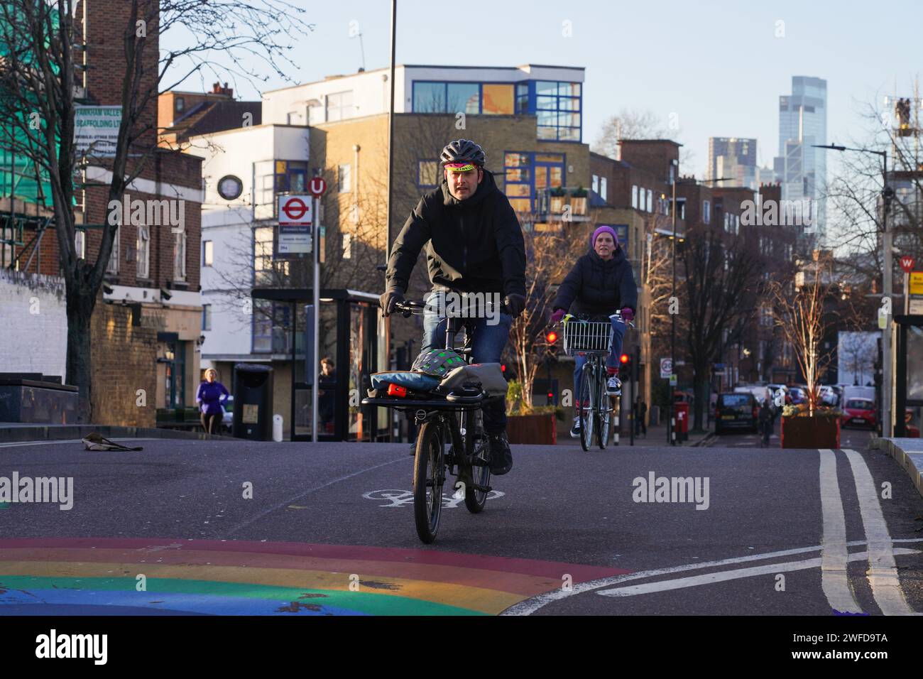 Bike riders commute in Hackney in the early morning winter sun on the ...