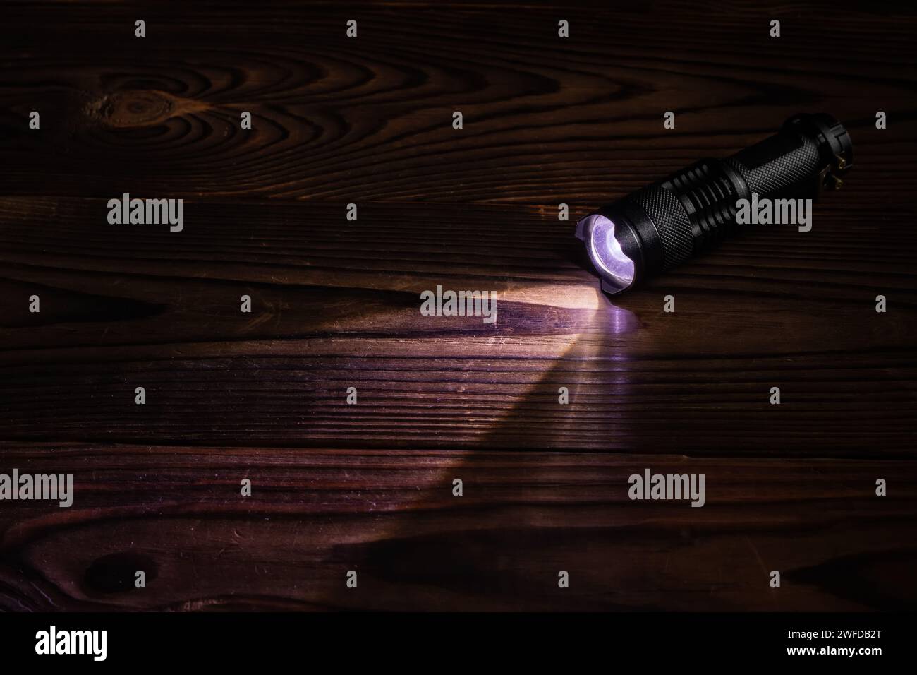 Flashlight and a beam of light in darkness. A modern led lamp with ...