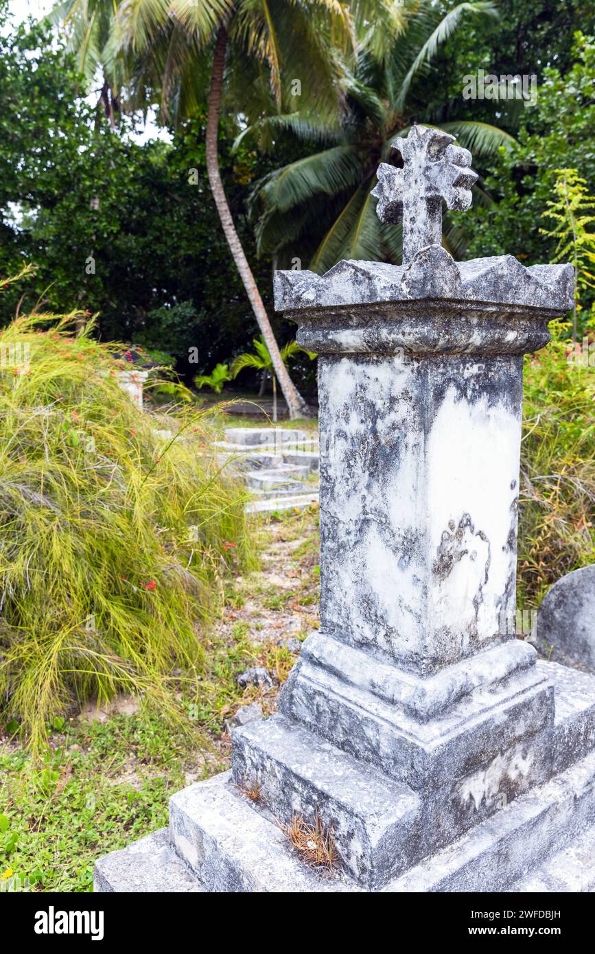 Gray gravestone with cross on top mounted at La Digue cemetery ...