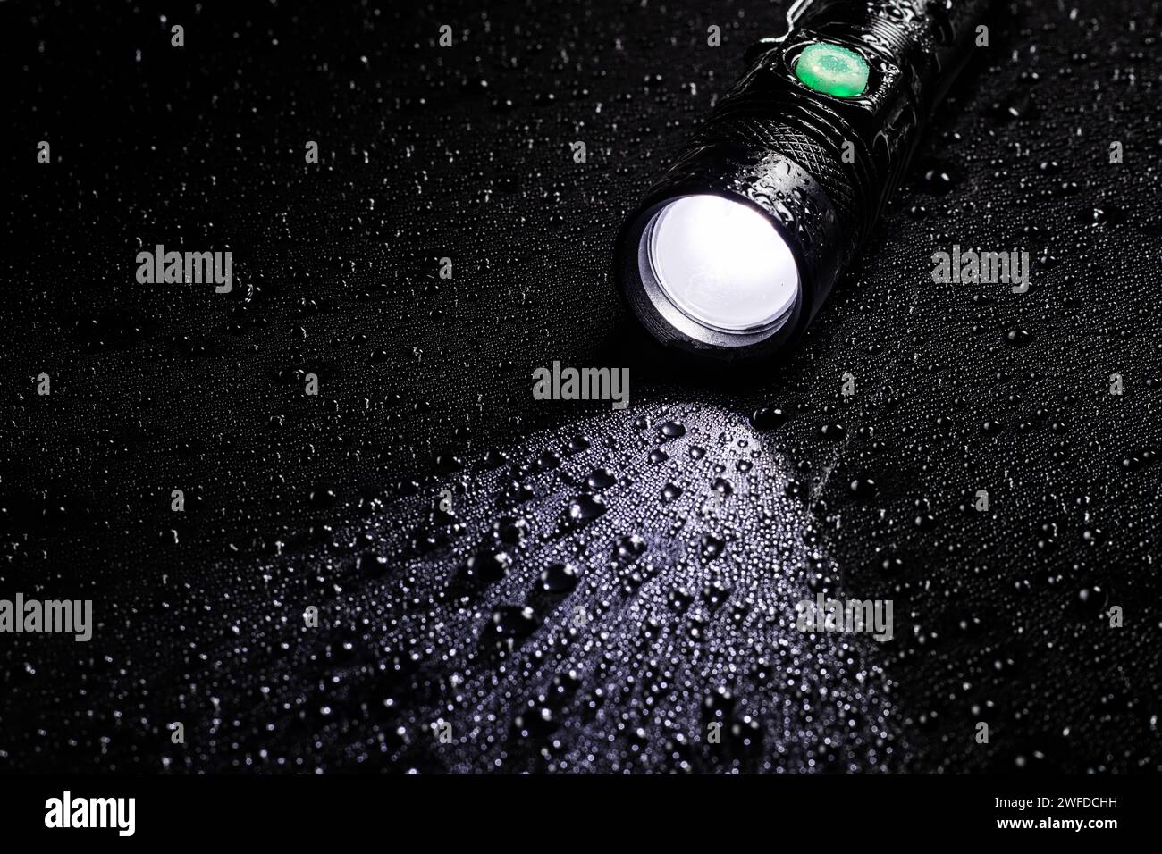 Flashlight water resistant in drops on black background Stock Photo - Alamy