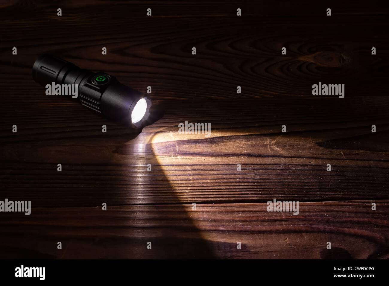 Flashlight and a beam of light in darkness. A modern led lamp with ...