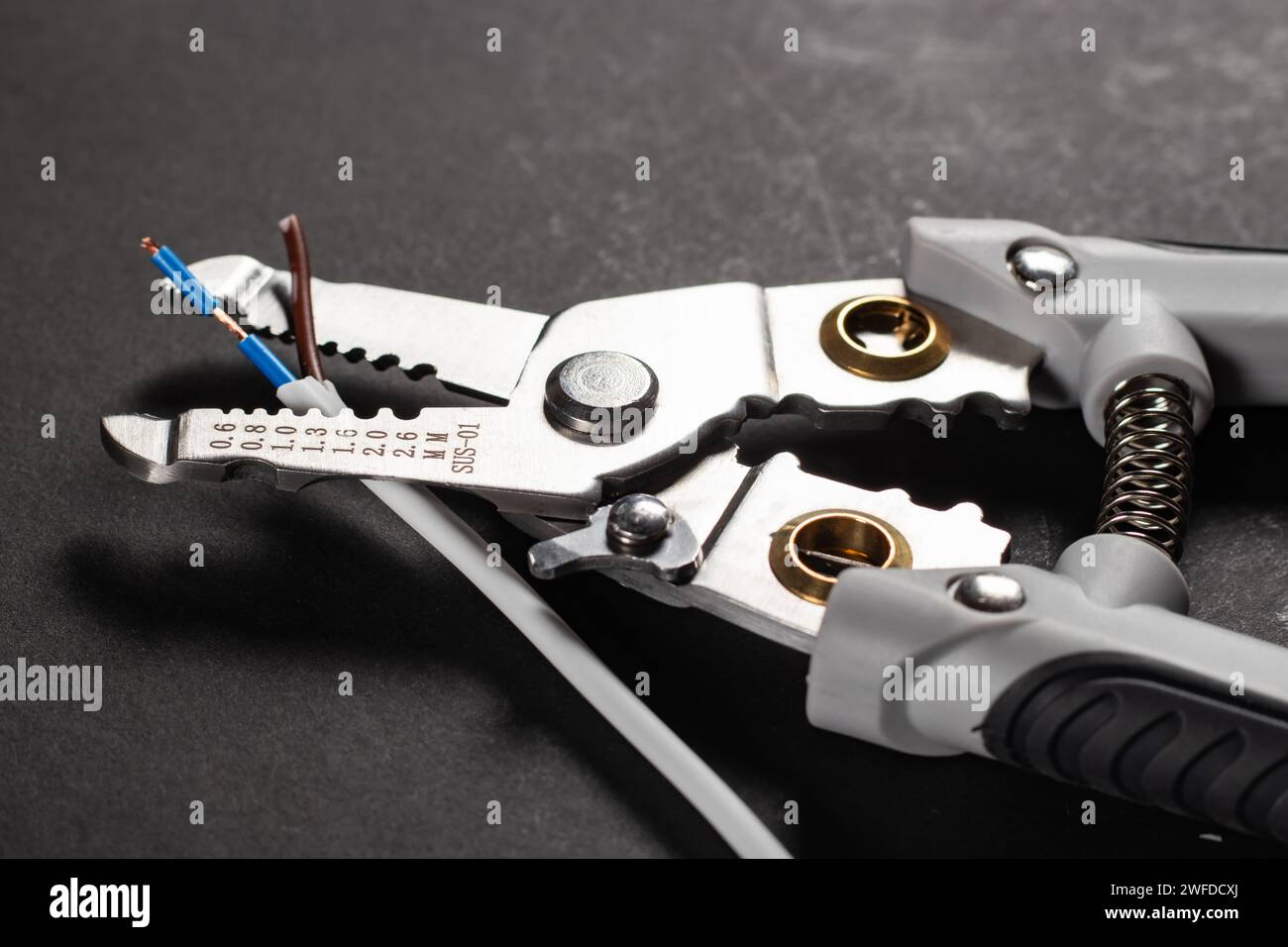 Removing the insulation from the conductor using a tool. Wire stripping ...