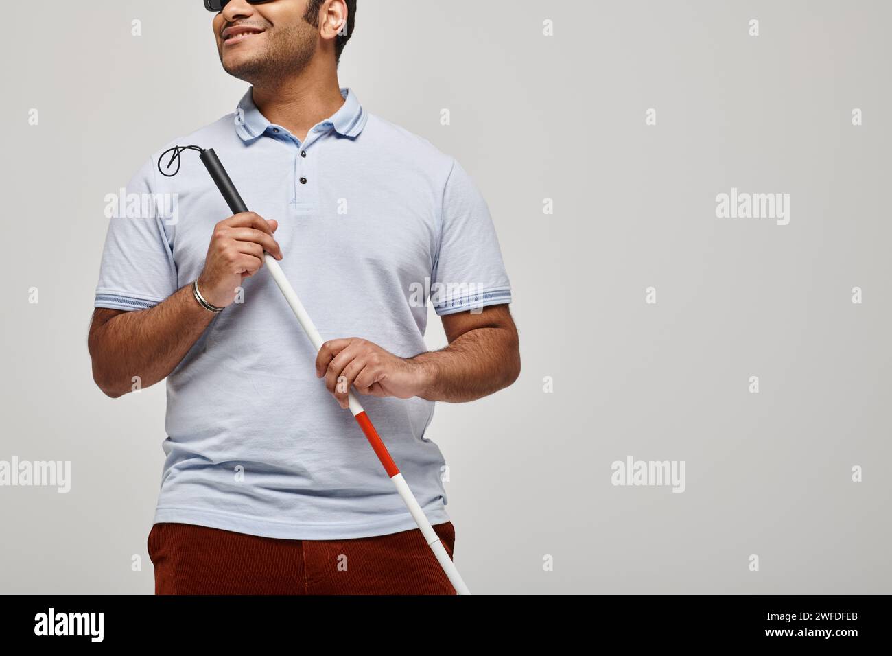 joyful indian blind man in blue tee shirt with glasses and walking ...