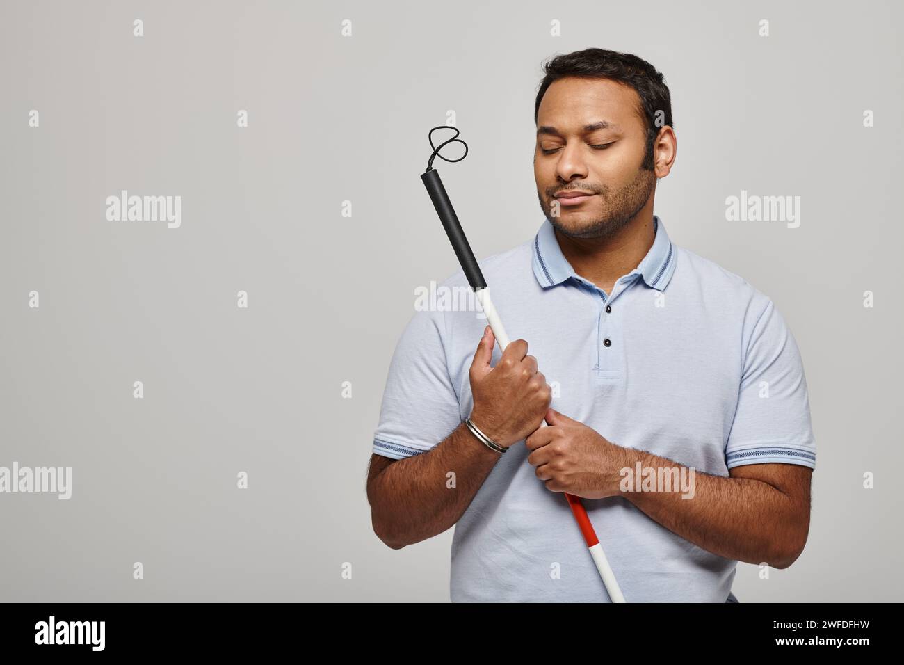 joyful indian disabled man in blue tee shirt holding walking stick and ...