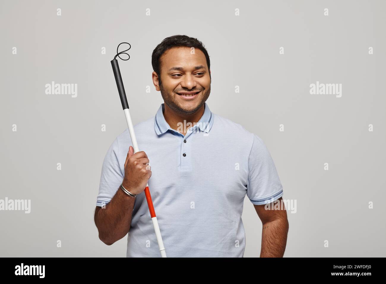 joyous indian disabled man in blue tee shirt holding walking stick and ...