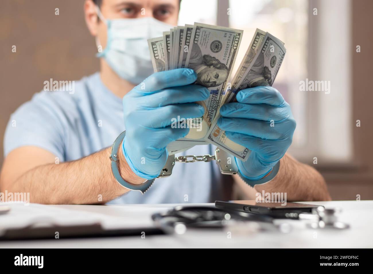 A doctor with dollar bank notes and handcuffs. concept of medical ...