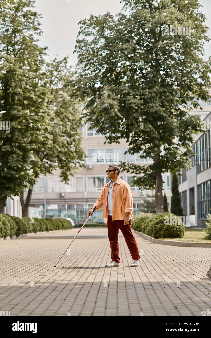 joyous indian blind man in orange jacket with glasses and walking stick ...