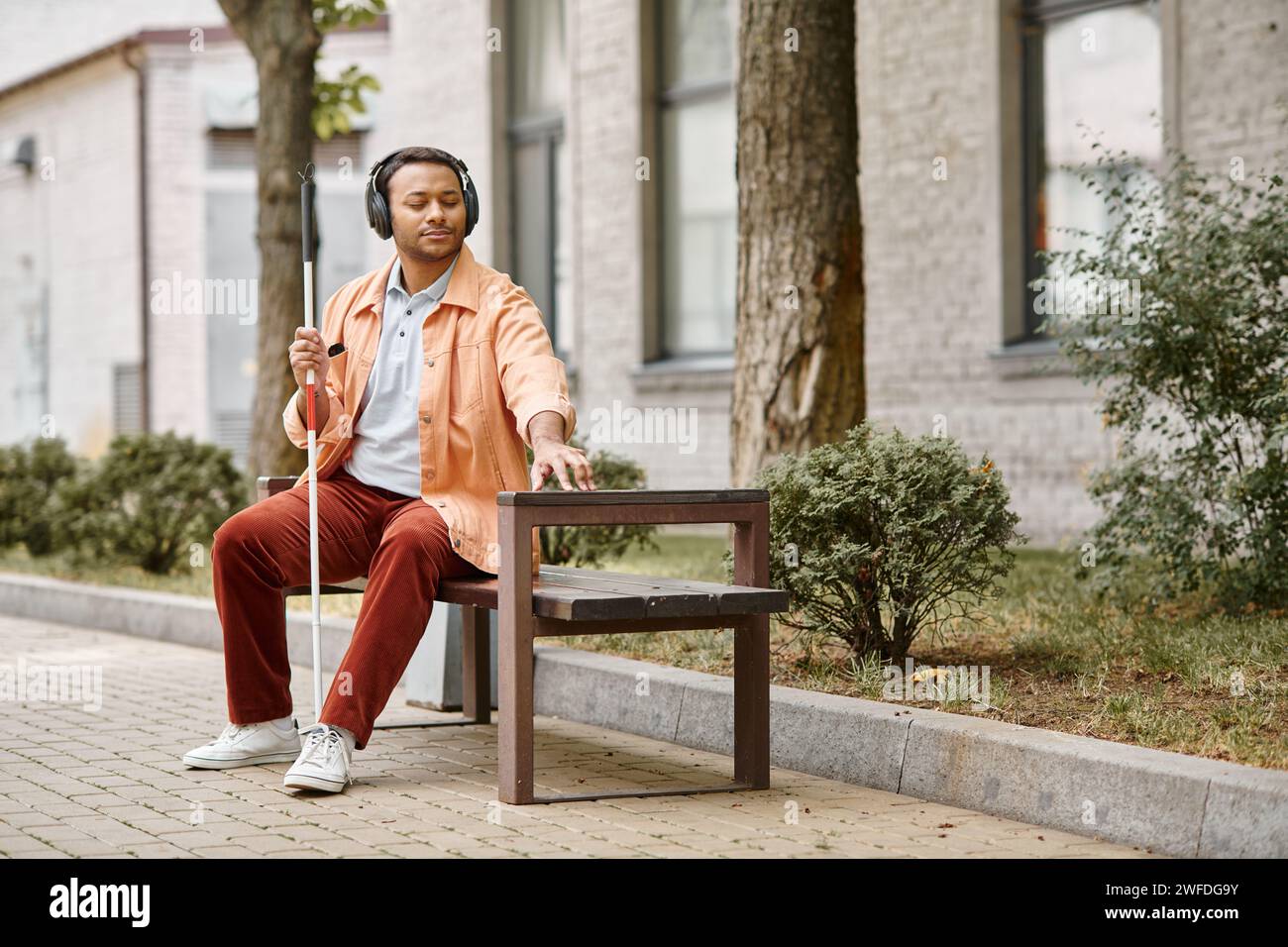 handsome disabled indian man in casual attire with headphones and ...