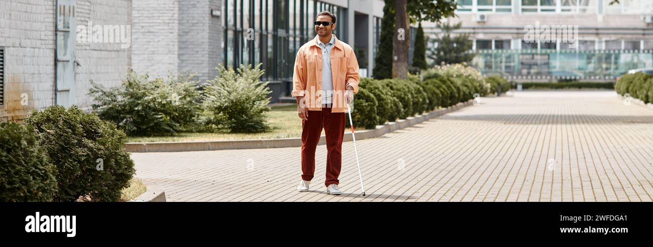 jolly indian blind man in orange jacket with glasses and walking stick ...
