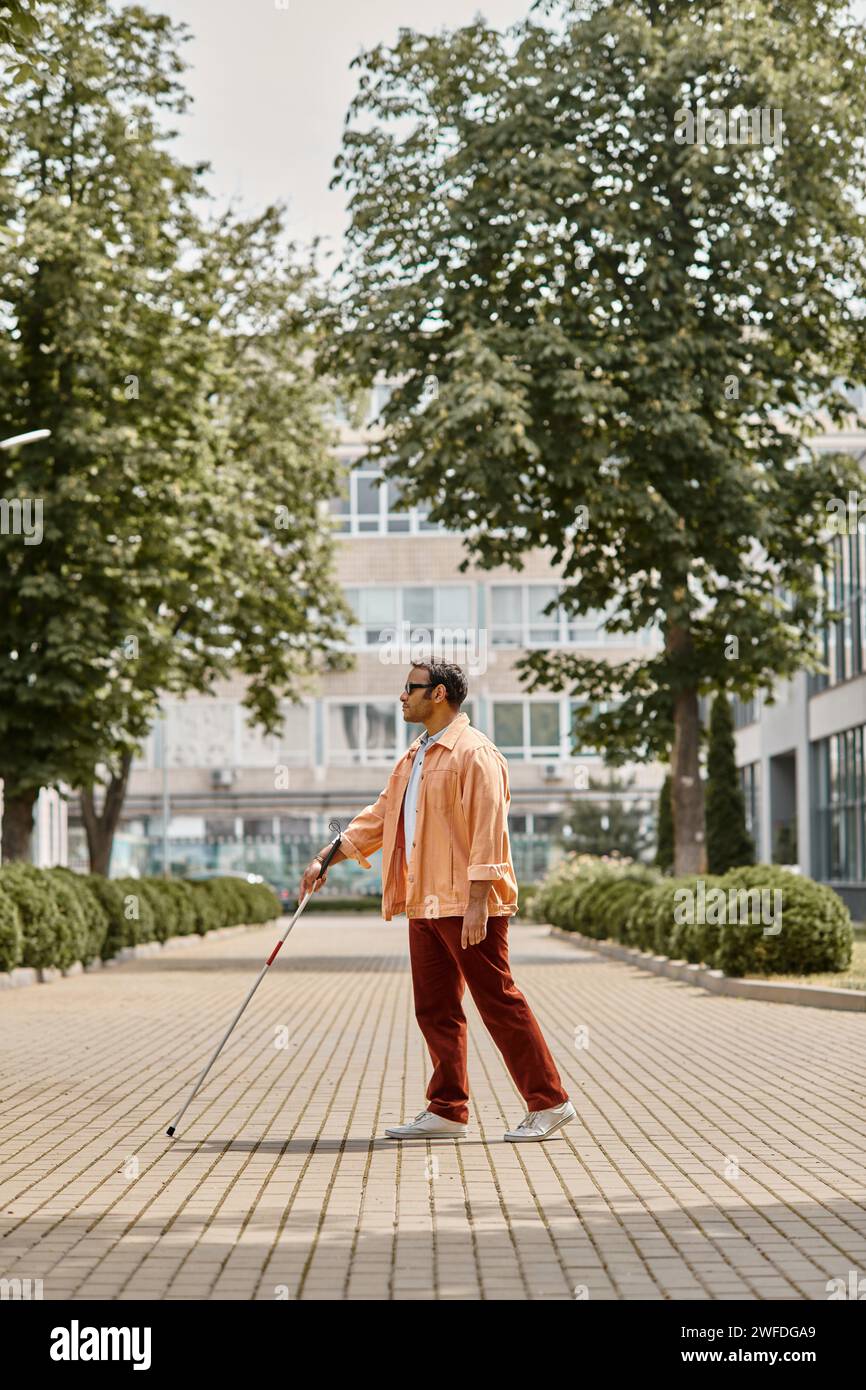 handsome indian blind man in orange jacket with glasses and walking ...