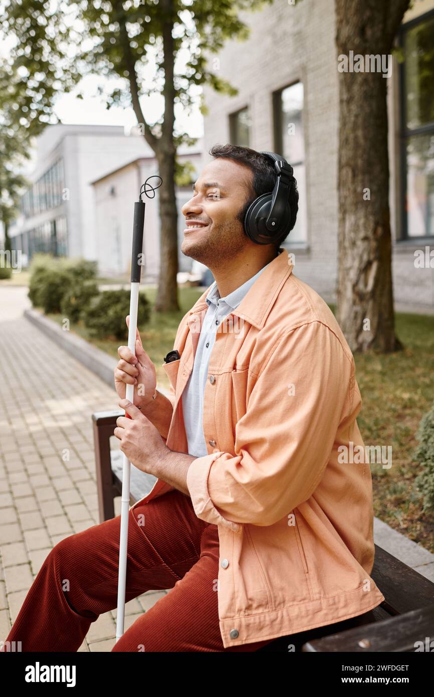 merry disabled indian man in casual outfit with headphones and walking ...