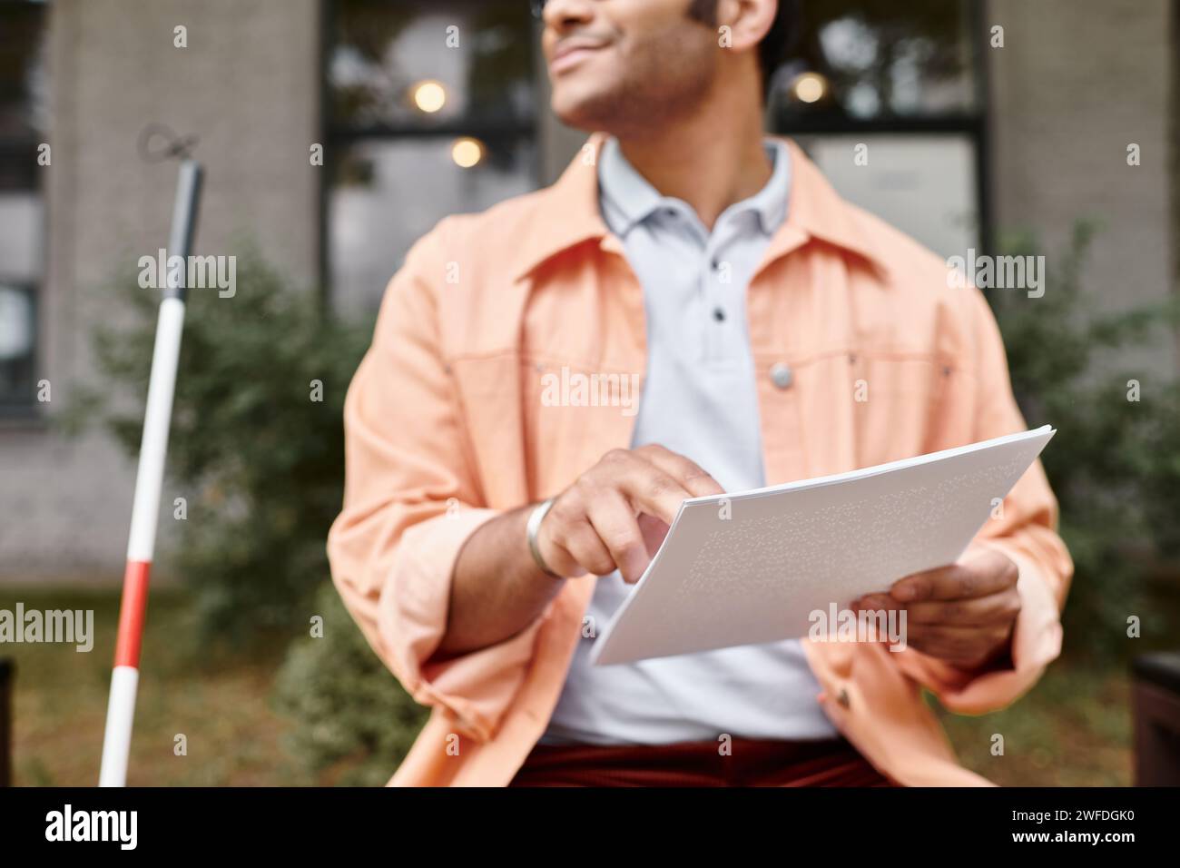 cropped view of indian man with visual impairment in vivid jacket on ...