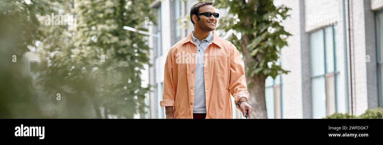 jolly indian blind man with glasses and walking stick in vivid orange ...