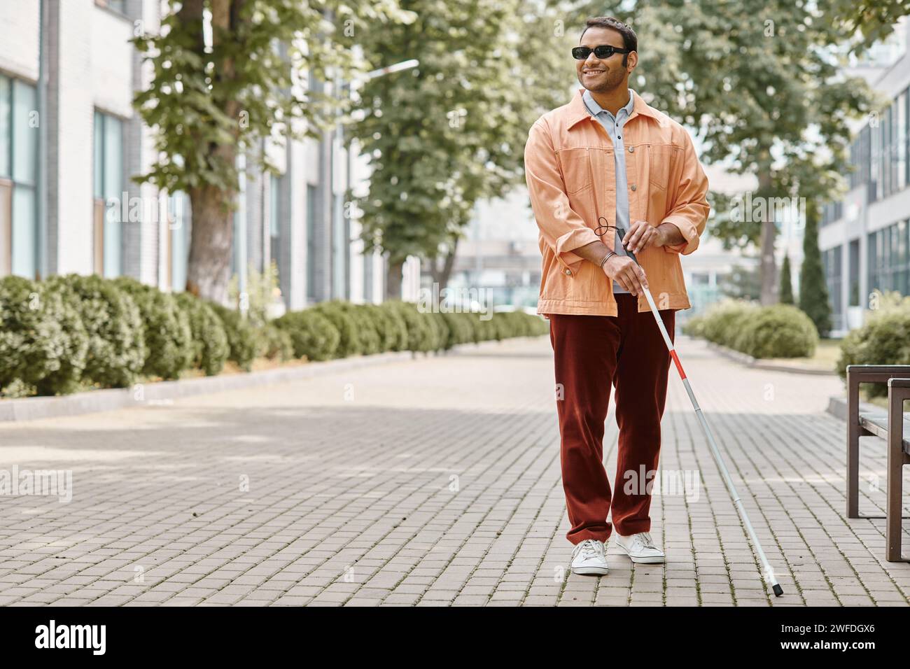 cheerful indian blind man with glasses and walking stick in orange ...