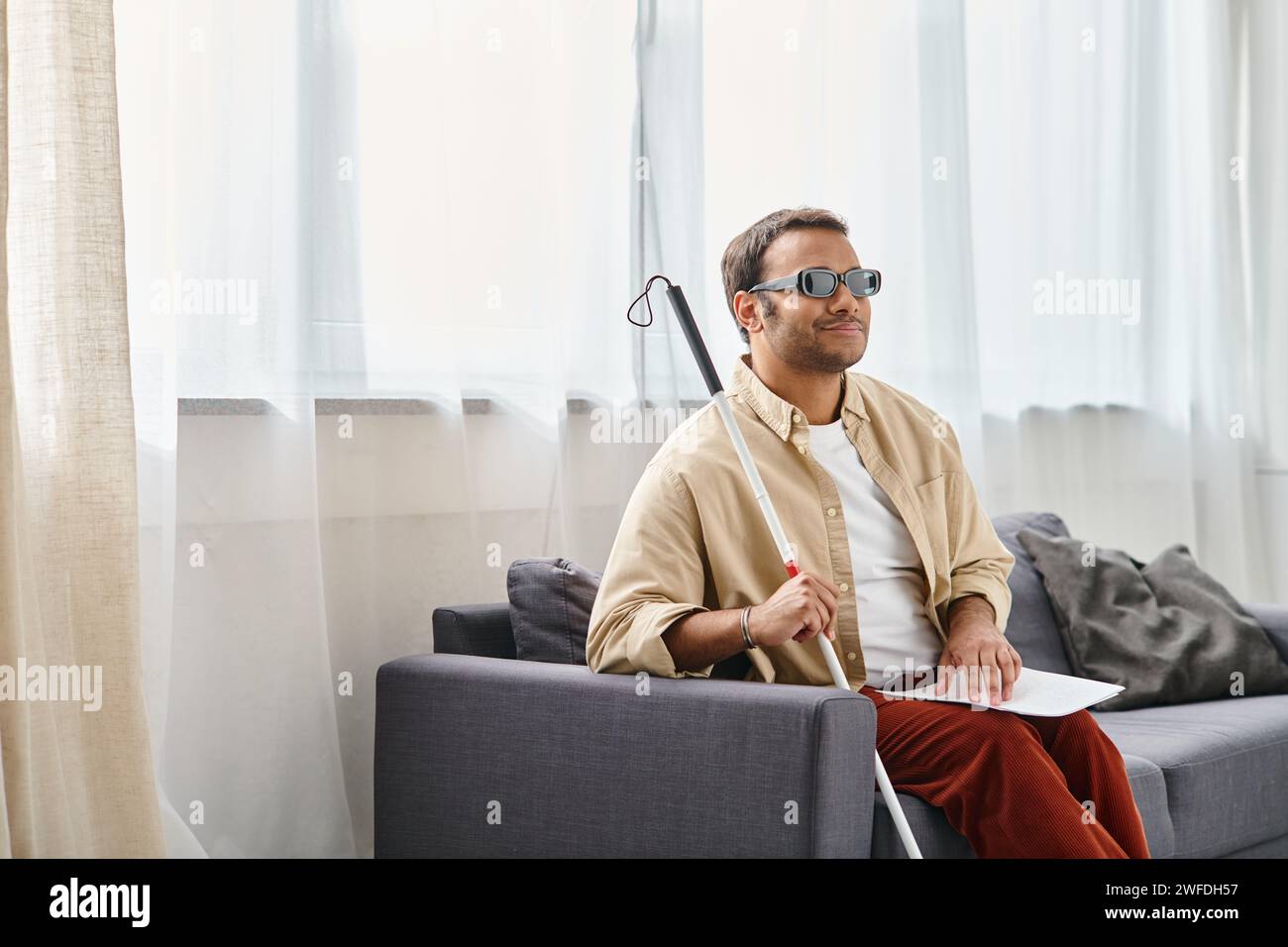 joyous indian man with visual impairment with glasses and walking stick ...