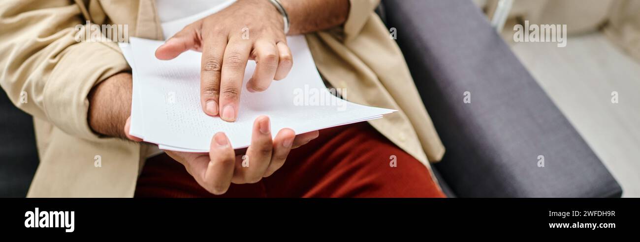 cropped view of indian blind man in casual attire sitting and reading ...