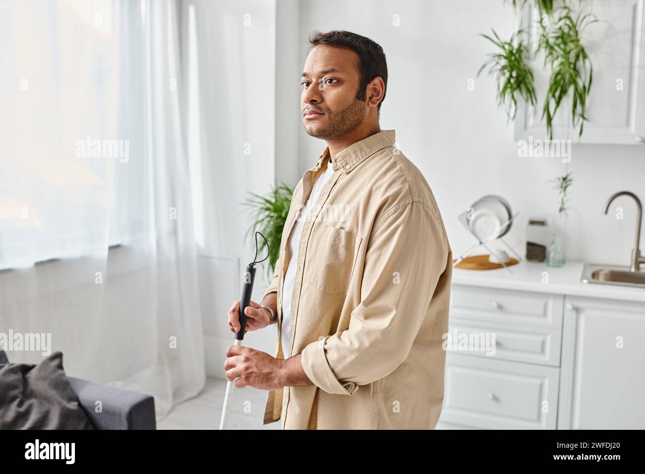 handsome blind indian man in comfortable homewear using walking stick ...