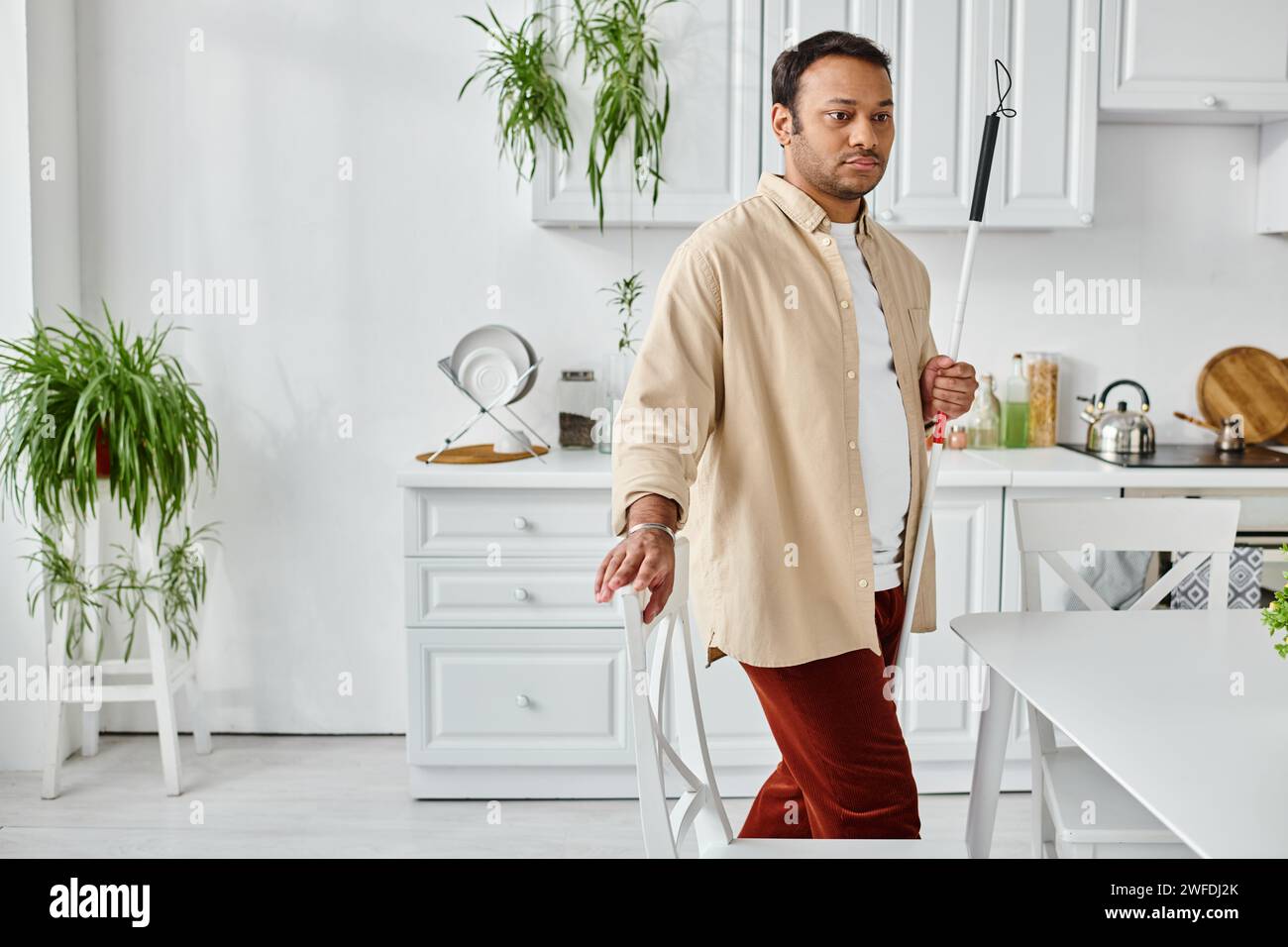 good looking indian man with visual impairment using walking stick ...