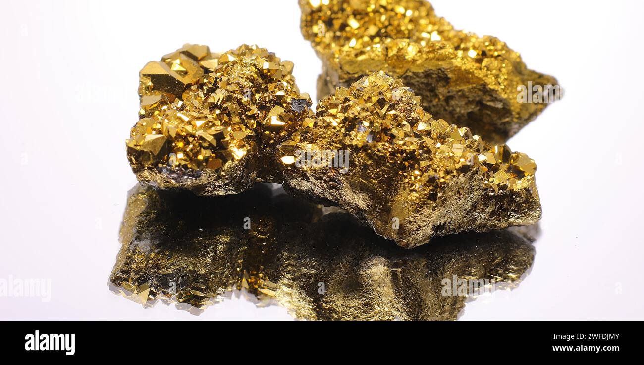 golden stones on the white background on a mirror Stock Photo - Alamy