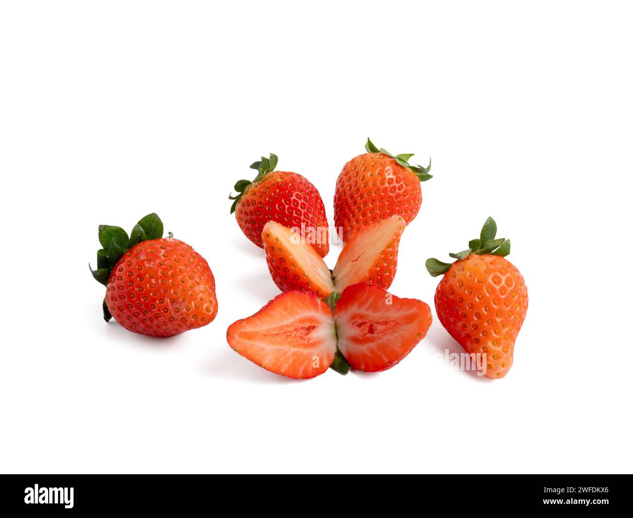Strawberries cut in half and whole on a white background. Strawberries ...